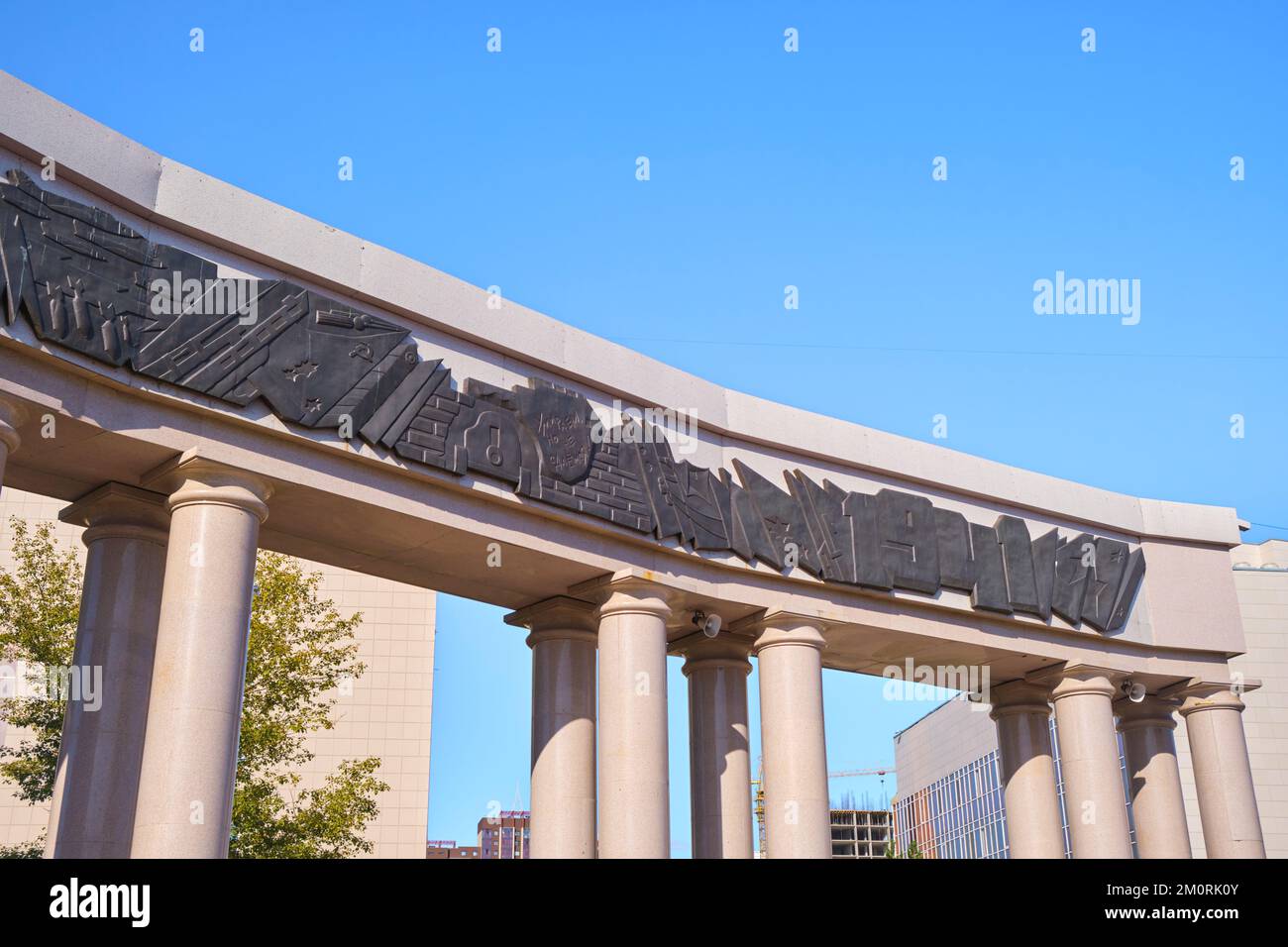 A bronze, circular frieze monument dedicated to WWII, located next to a ...