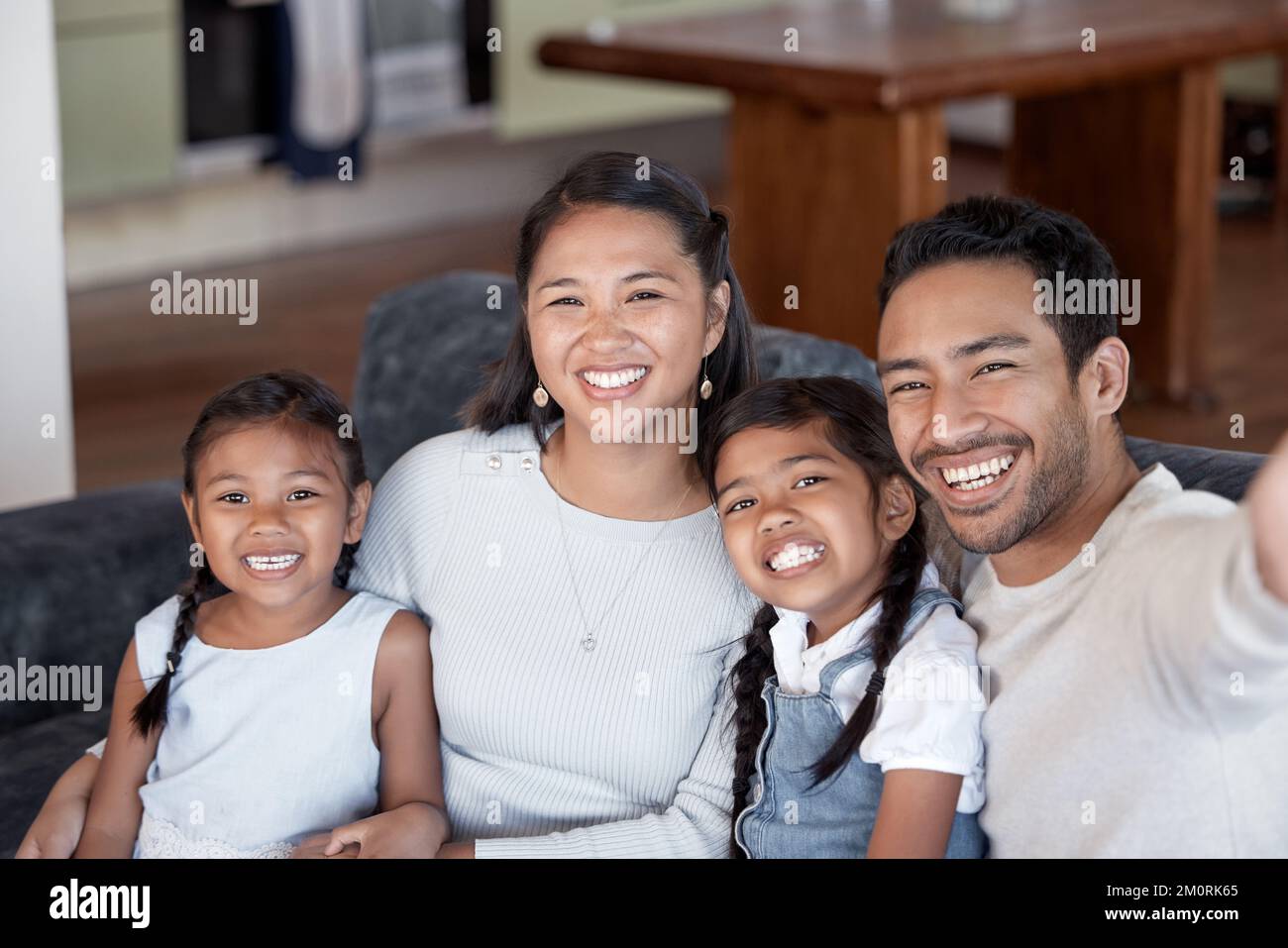 Family smiles. Cropped portrait of an affectionate young family of four taking selfies on the ...