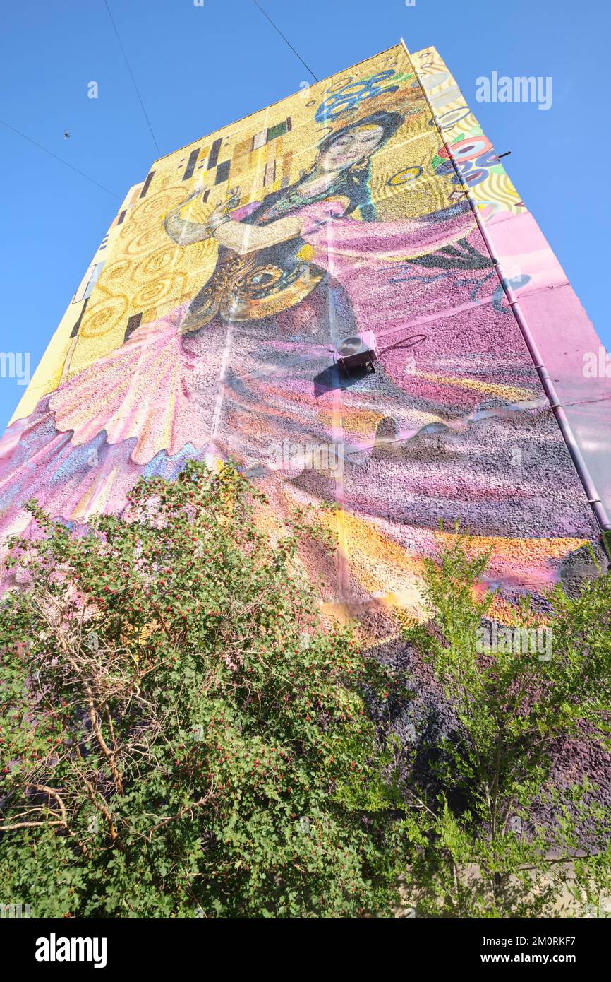 A giant painted mural on the end of a large apartment building ...