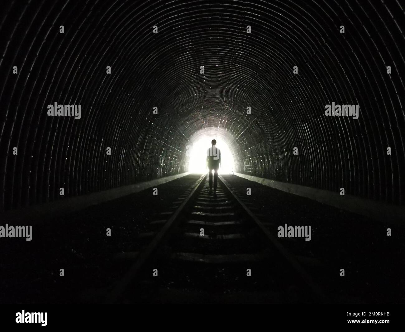 People pass through abandoned train tunnel Stock Photo - Alamy
