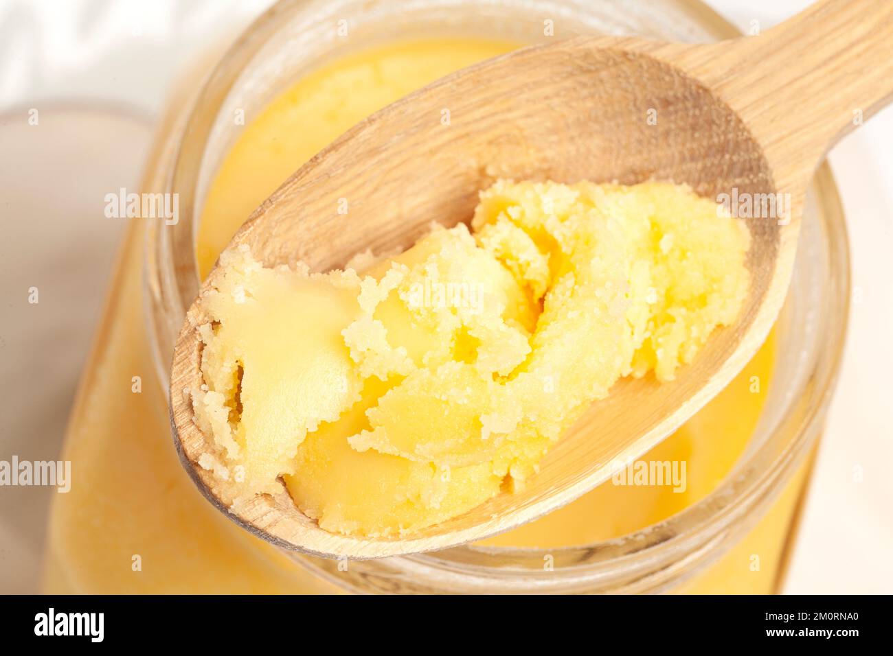 Ghee in jar and wooden spoon isolated on white background,top view ...