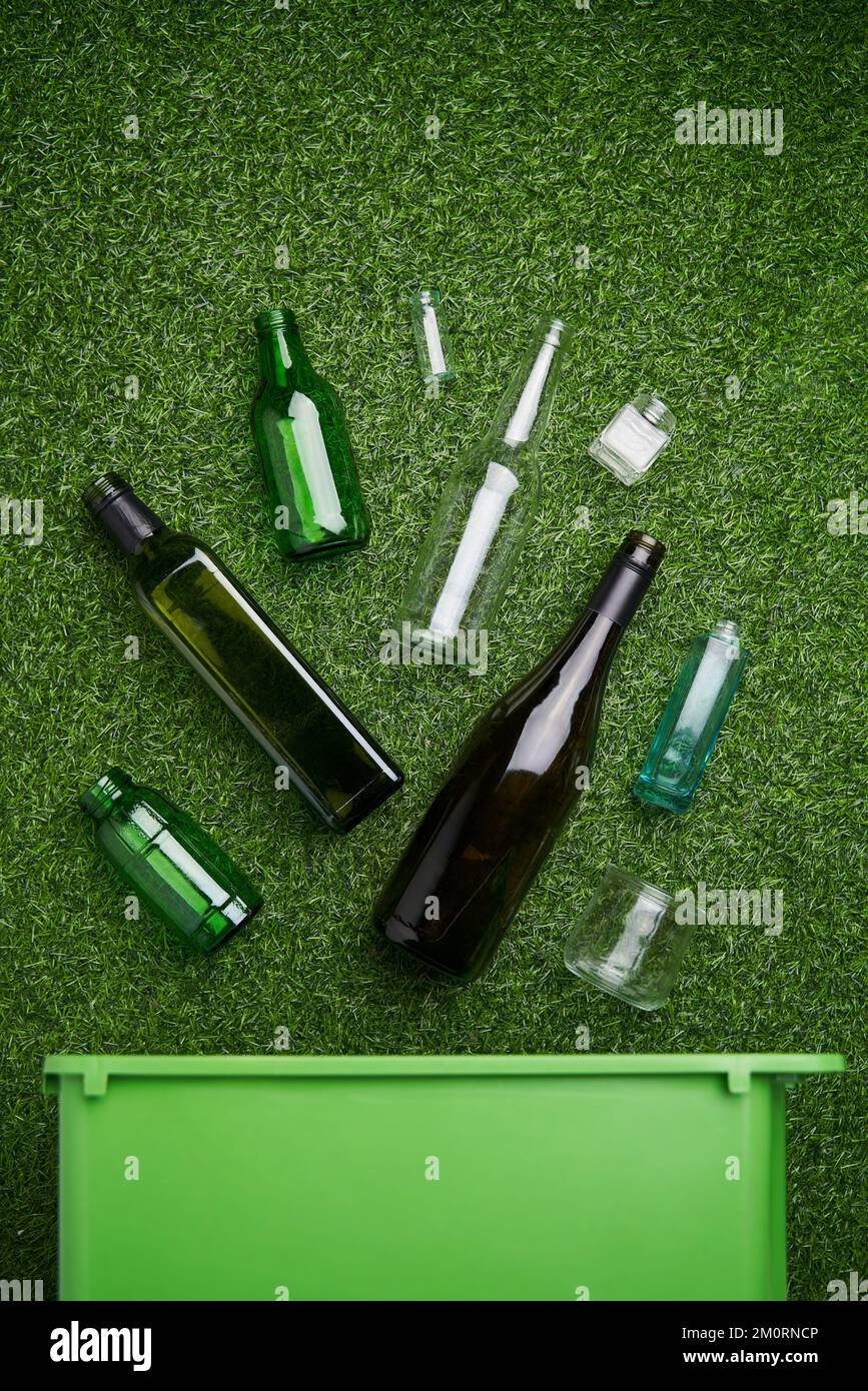 Separate collection of glass garbage. Recyclable glass waste on green ...