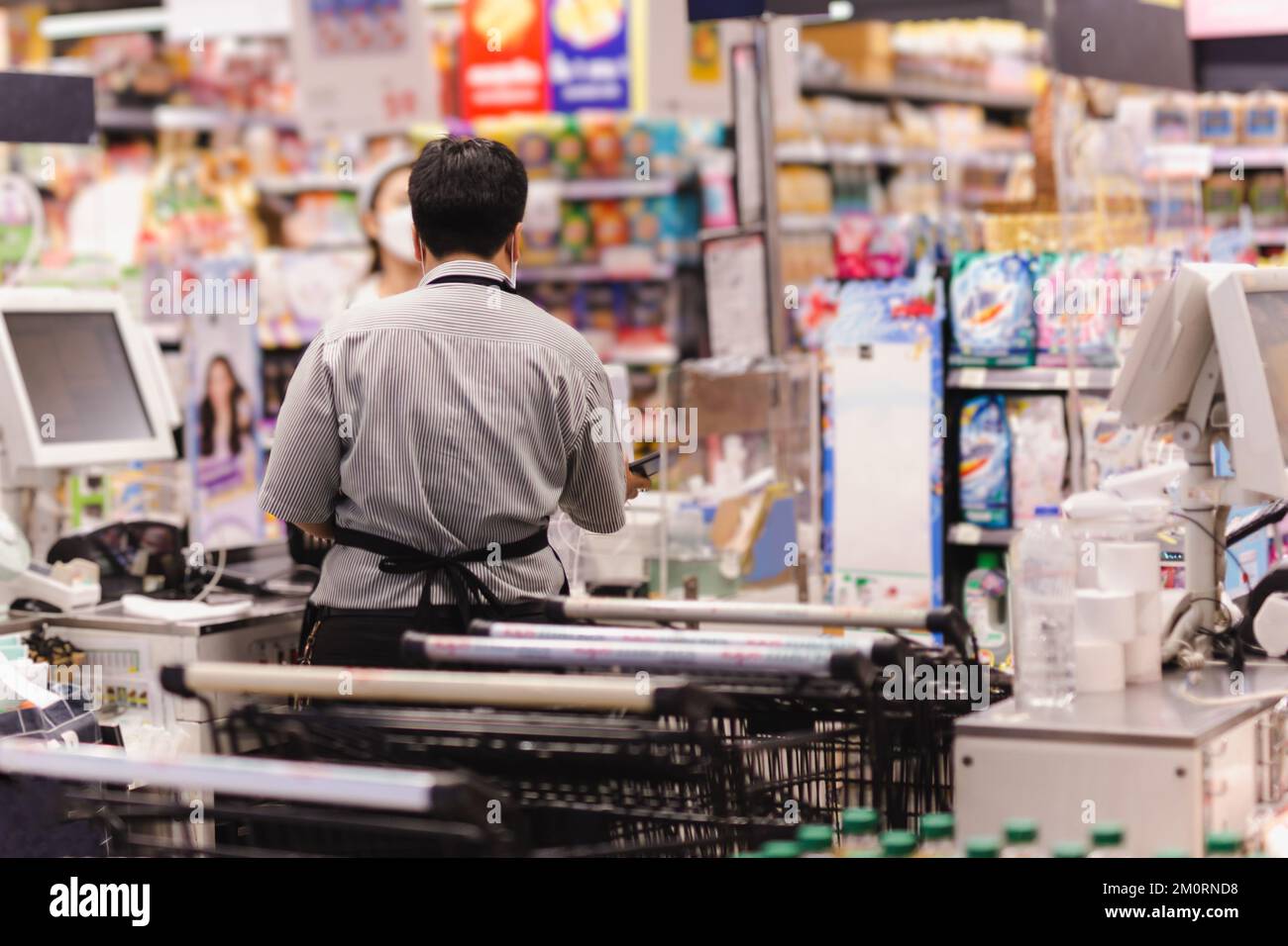 Back view of man working at cashier desk at shopping store Stock Photo ...