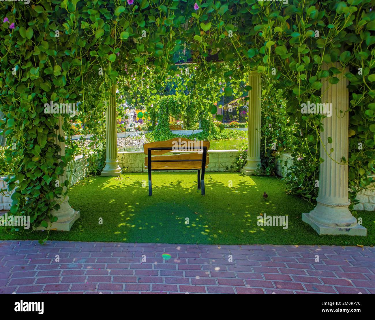 A single bench facing backwards inside an outdoor structure in a park ...
