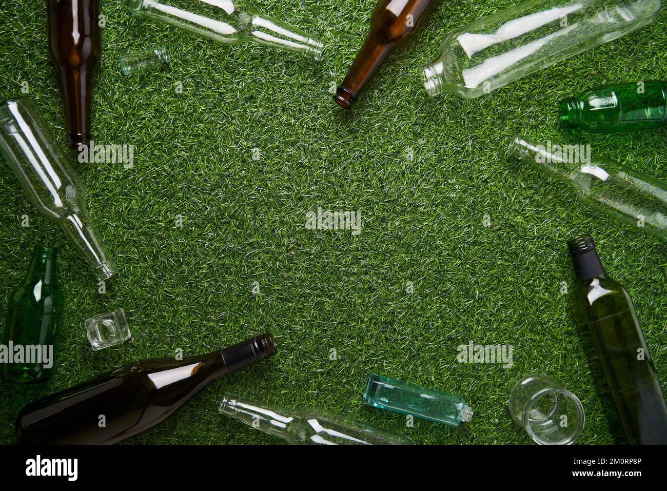 Separate collection of glass garbage. Recyclable glass waste on green ...