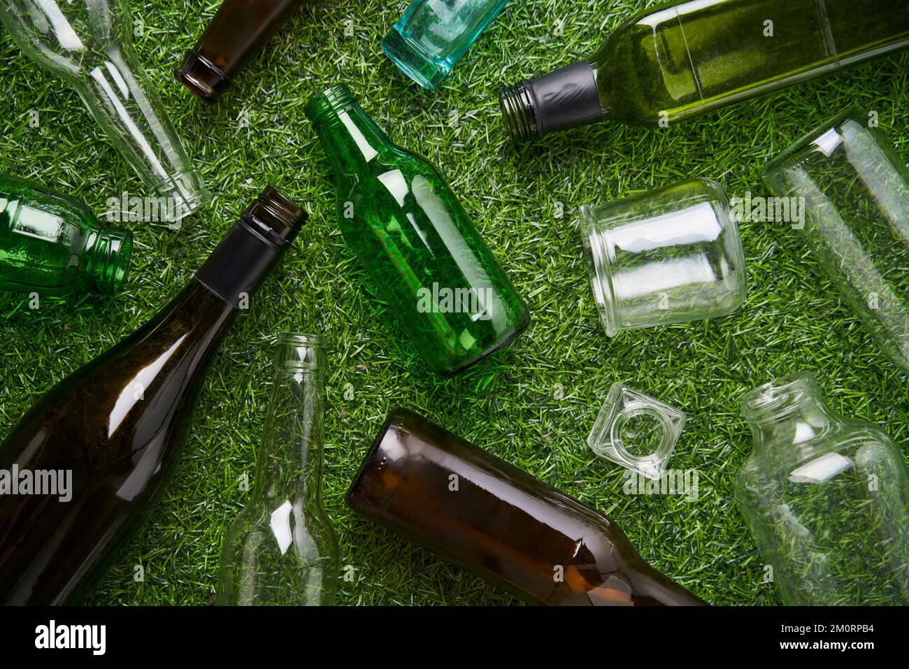 Separate collection of glass garbage. Recyclable glass waste on green ...