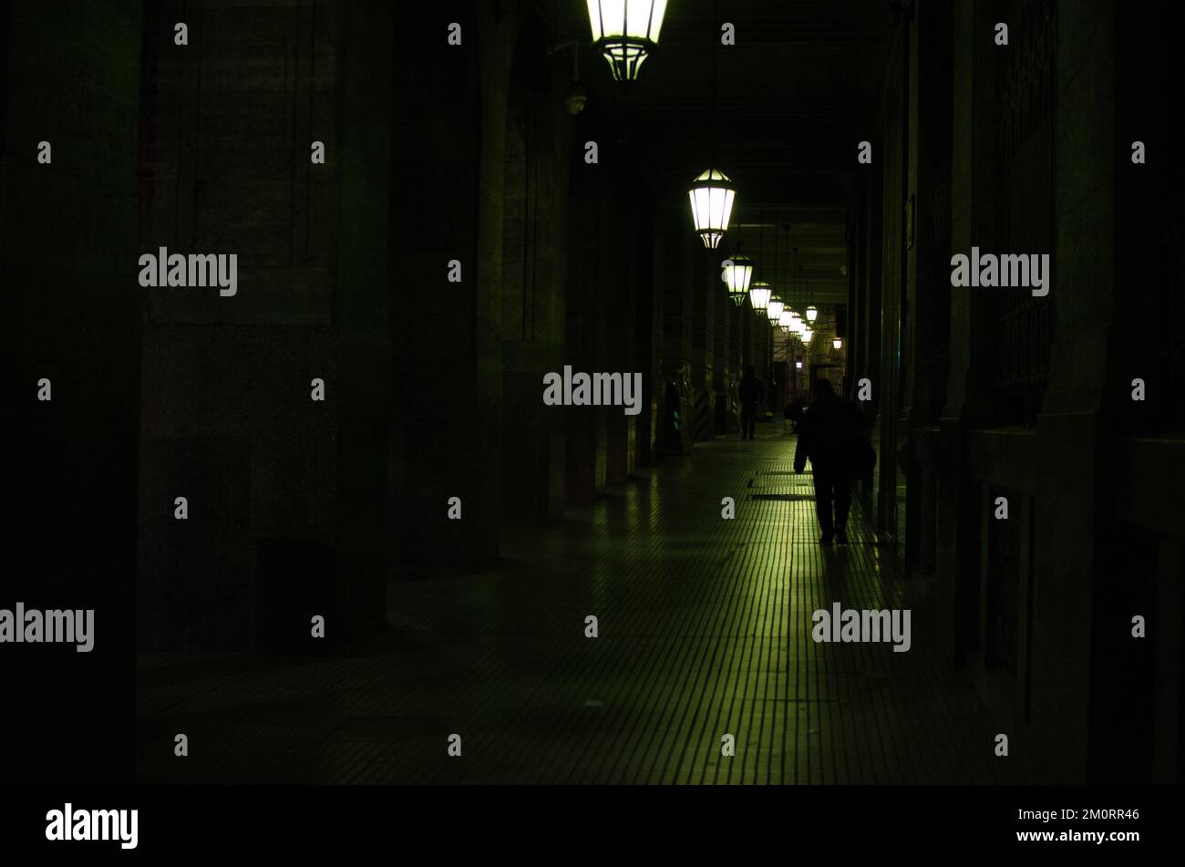 A night view of a lighted alley surrounded by buildings, with ...