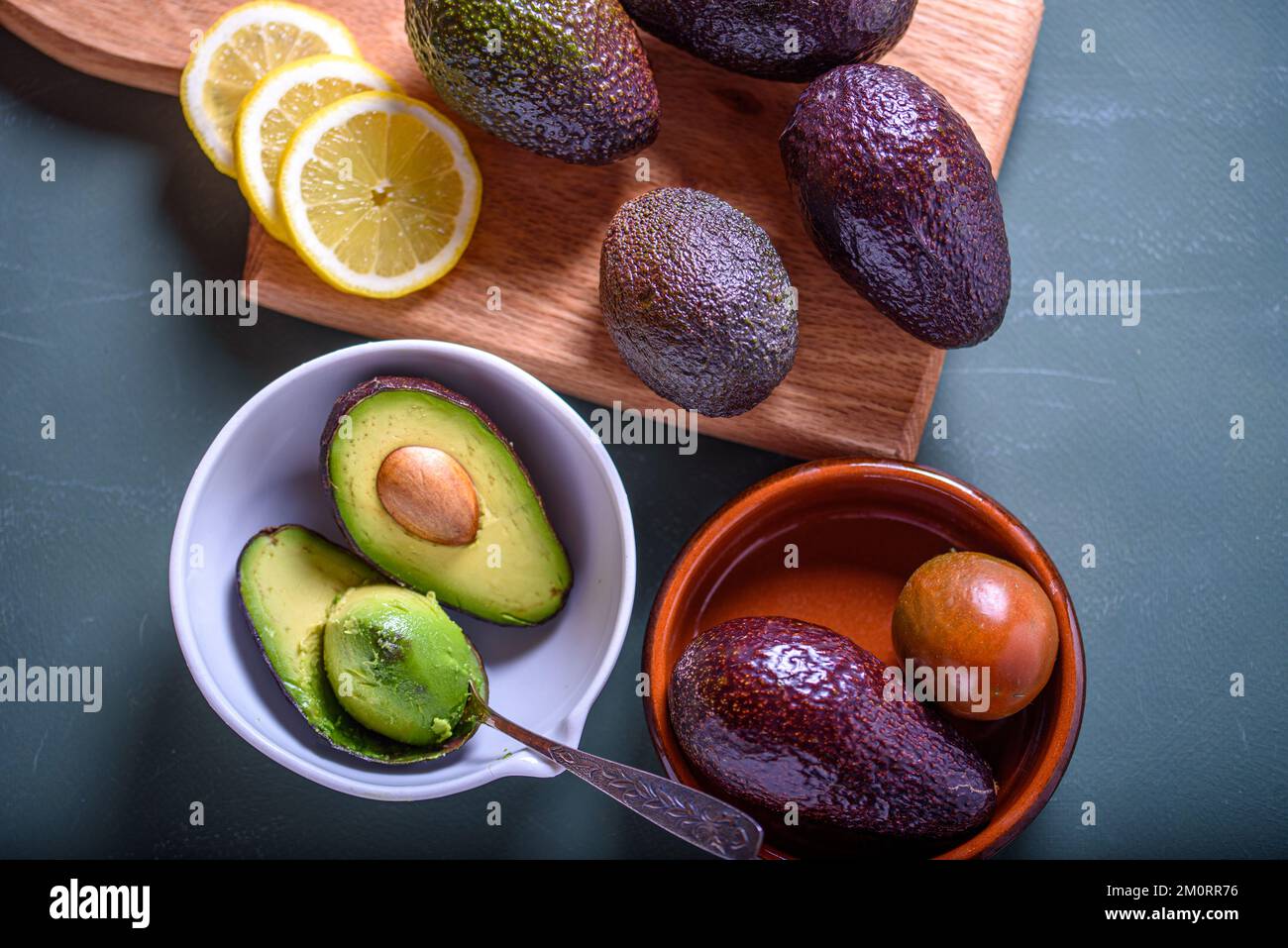 Fresh avocado and tomato in bowl. Avocado and citrus slices on the ...