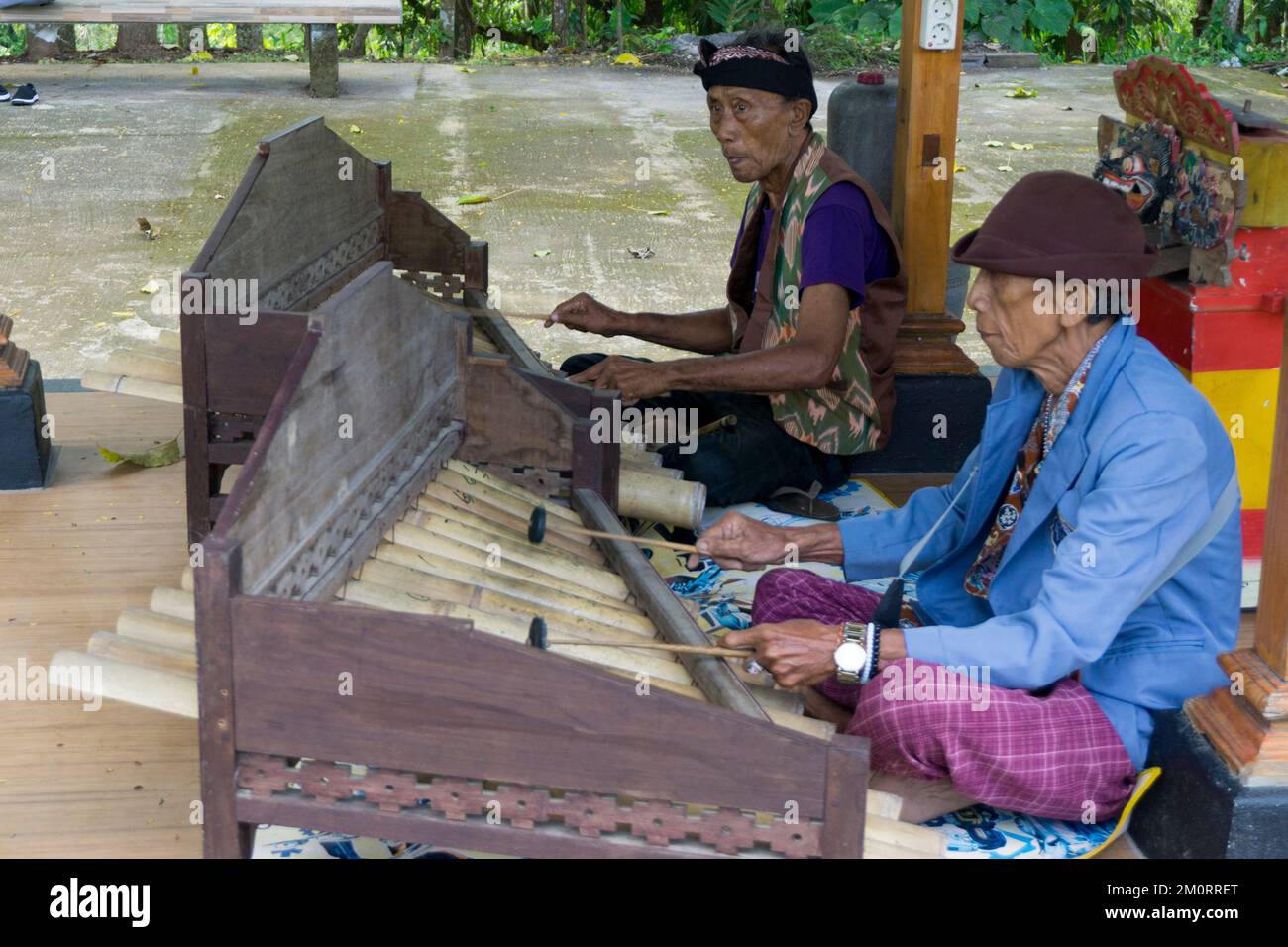 An old Asian man playing a Balinese musical instrument Stock Photo - Alamy