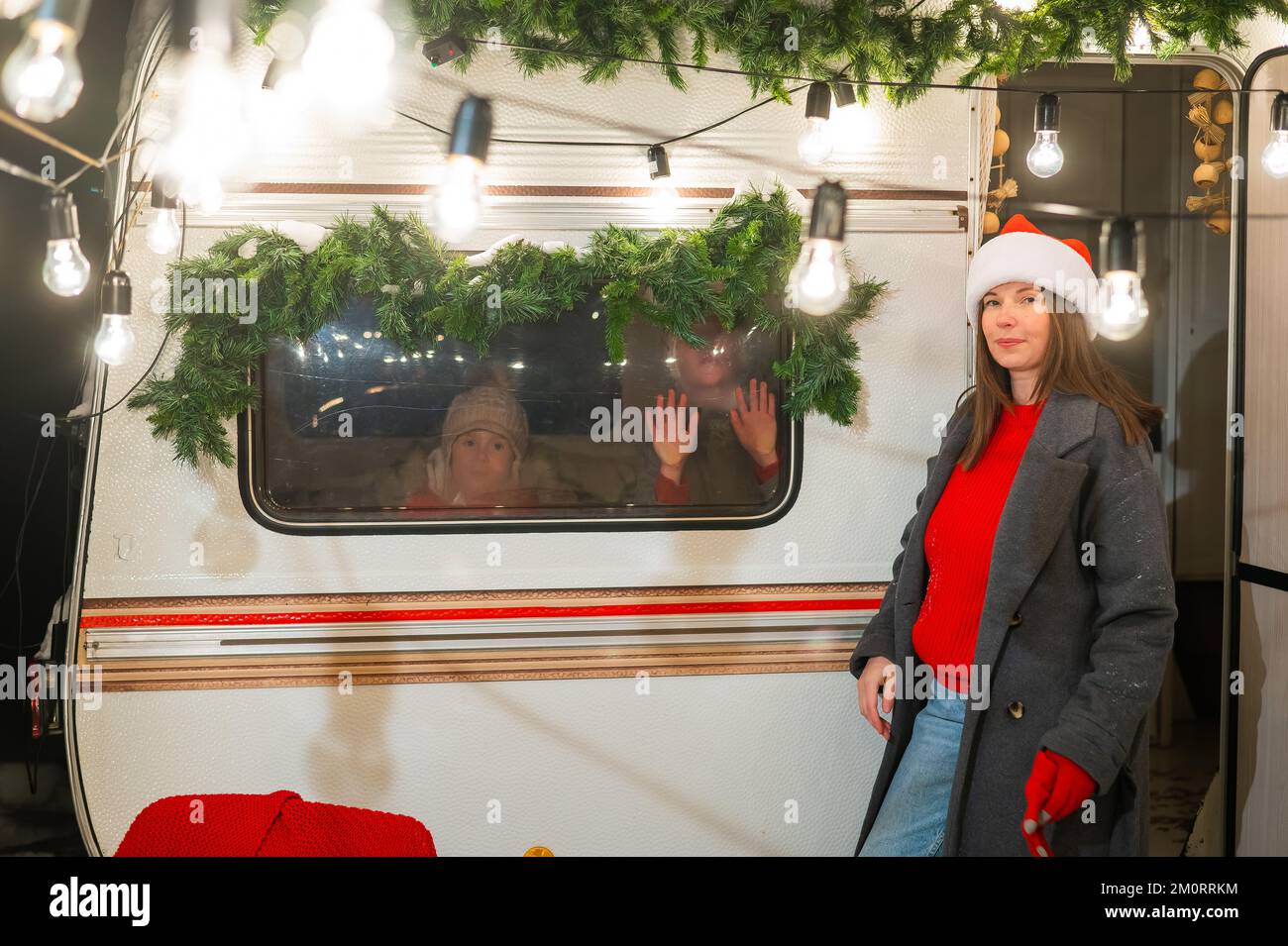 Caucasian woman and two with sons celebrate Christmas in a camper. Mom ...