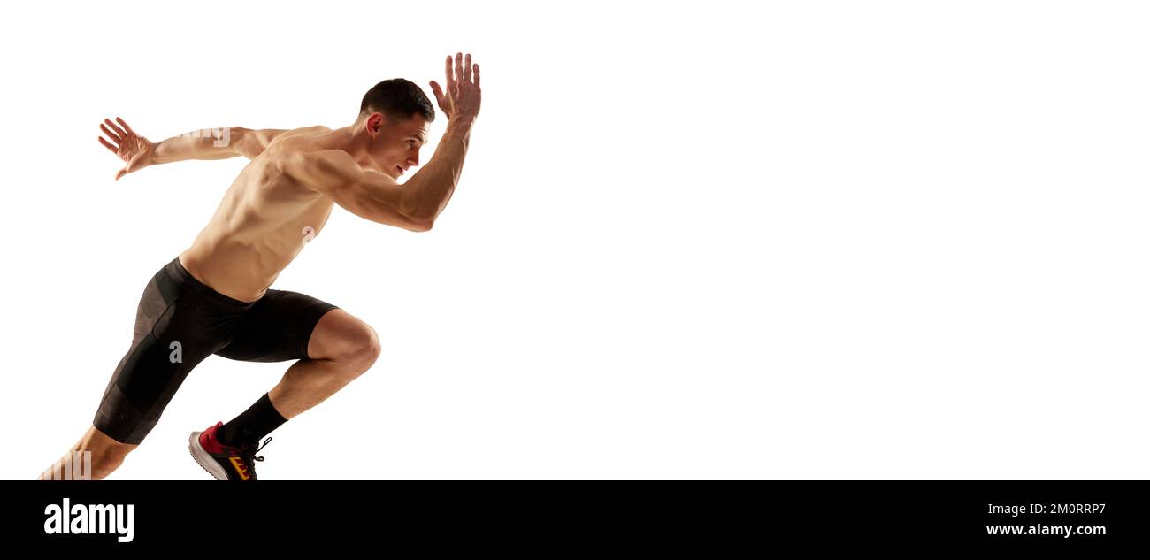 Sportive man, muscular athlete, runner wearing bicycle shorts in motion and action isolated over ...