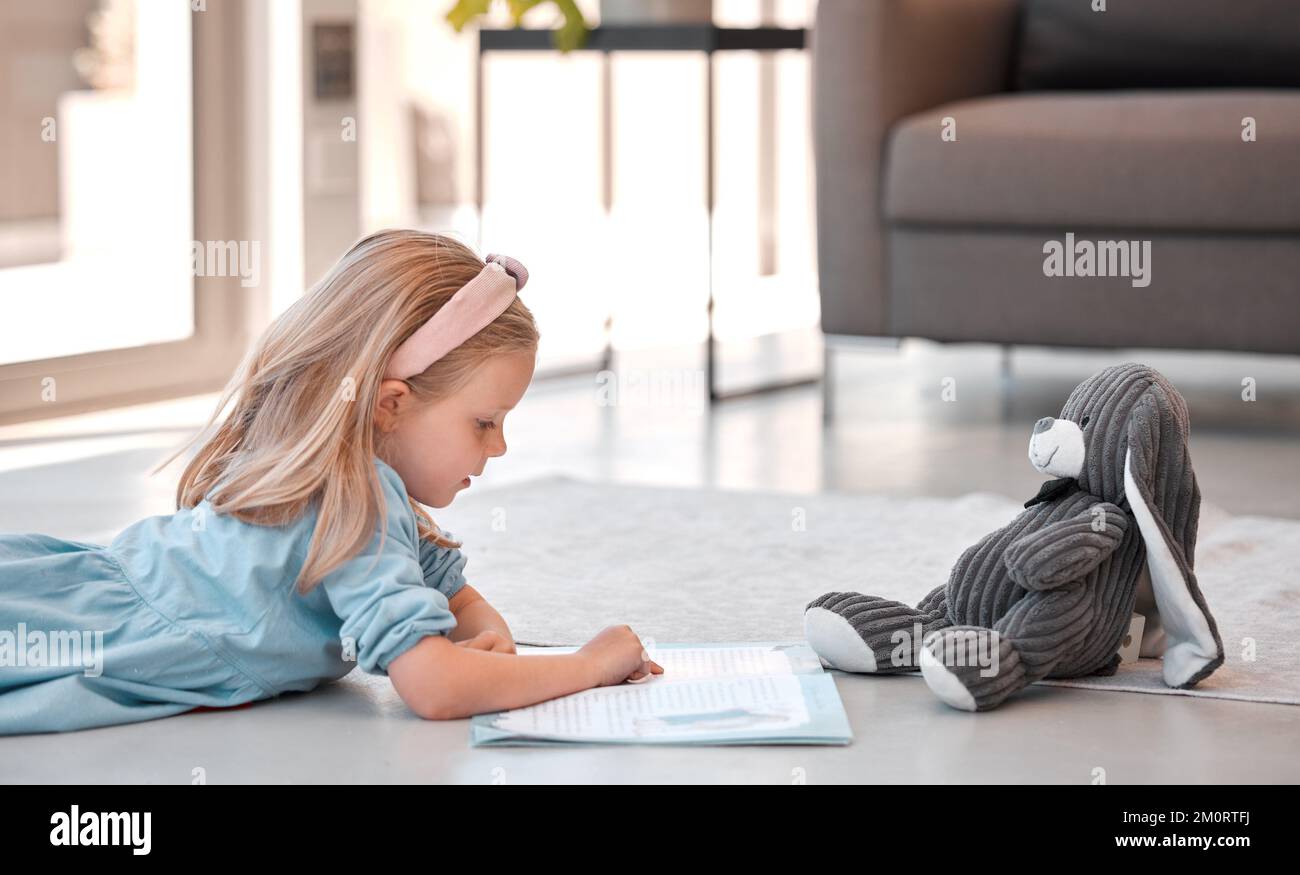 Little girl reading storybook at home with teddybear. Adorable ...