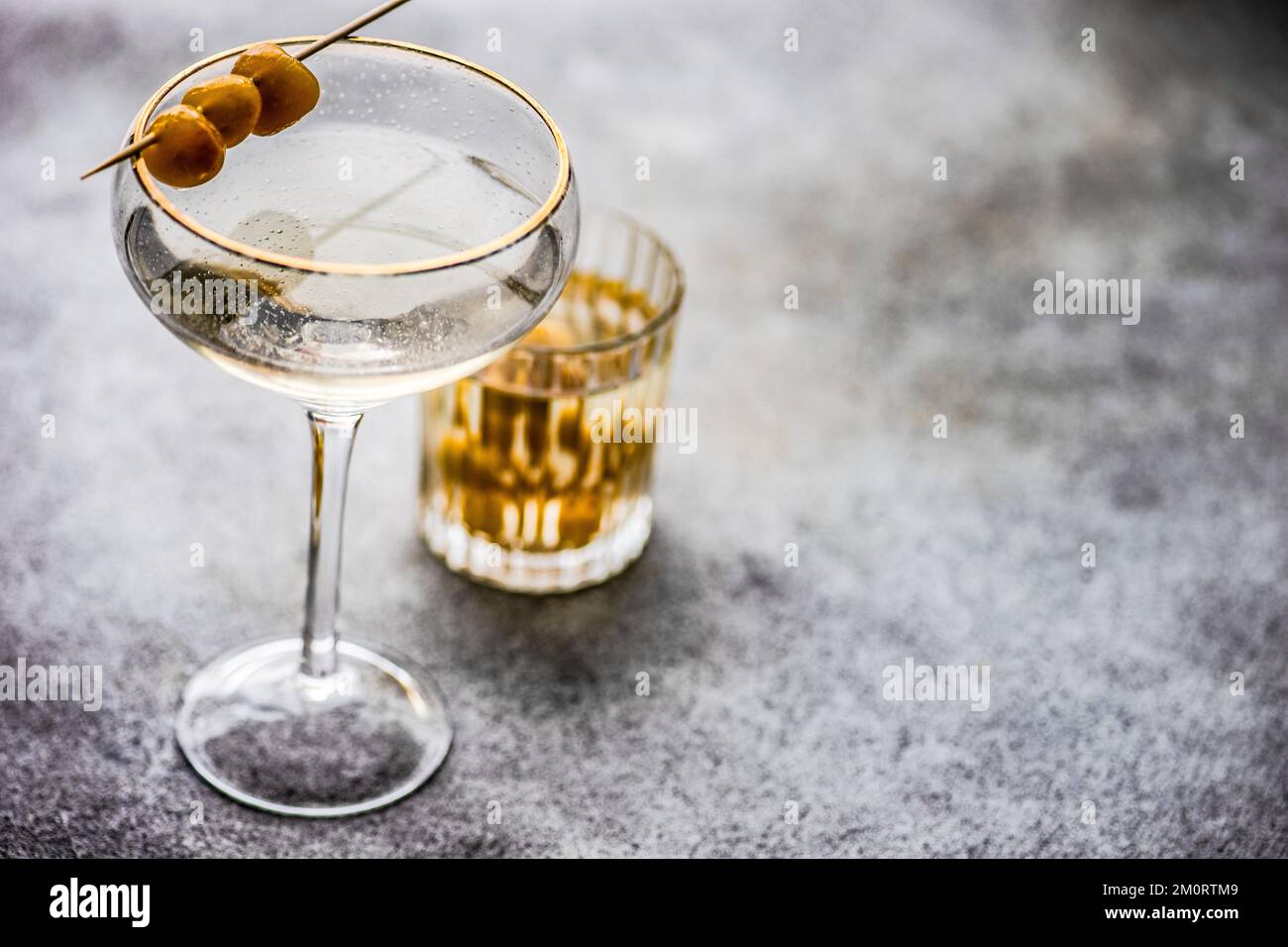 Close-up of a vodka cocktail and a tumbler filled with yellow glace ...