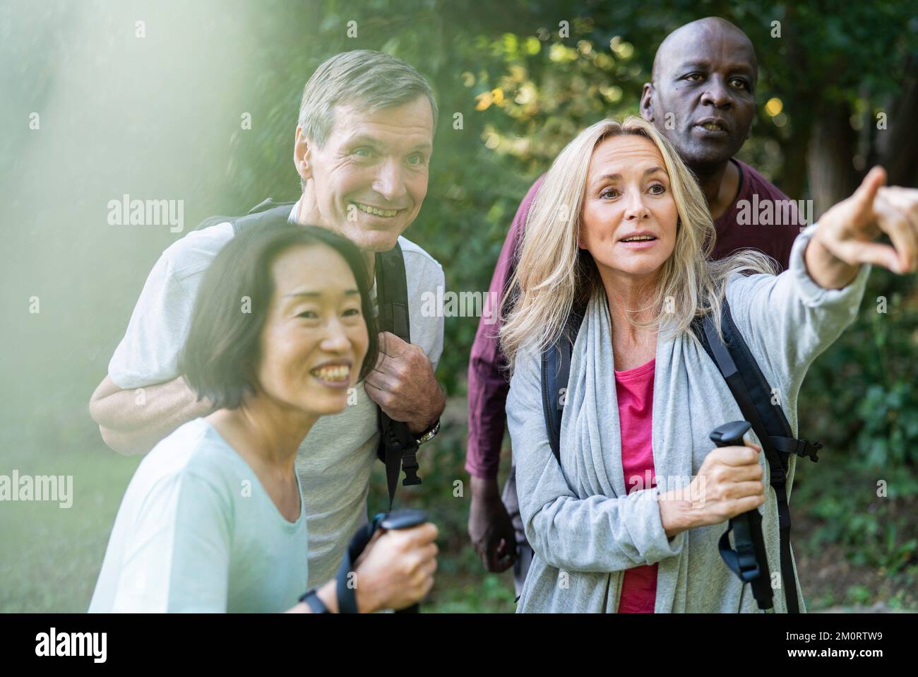 Senior woman giving directions to diverse group of people while ...