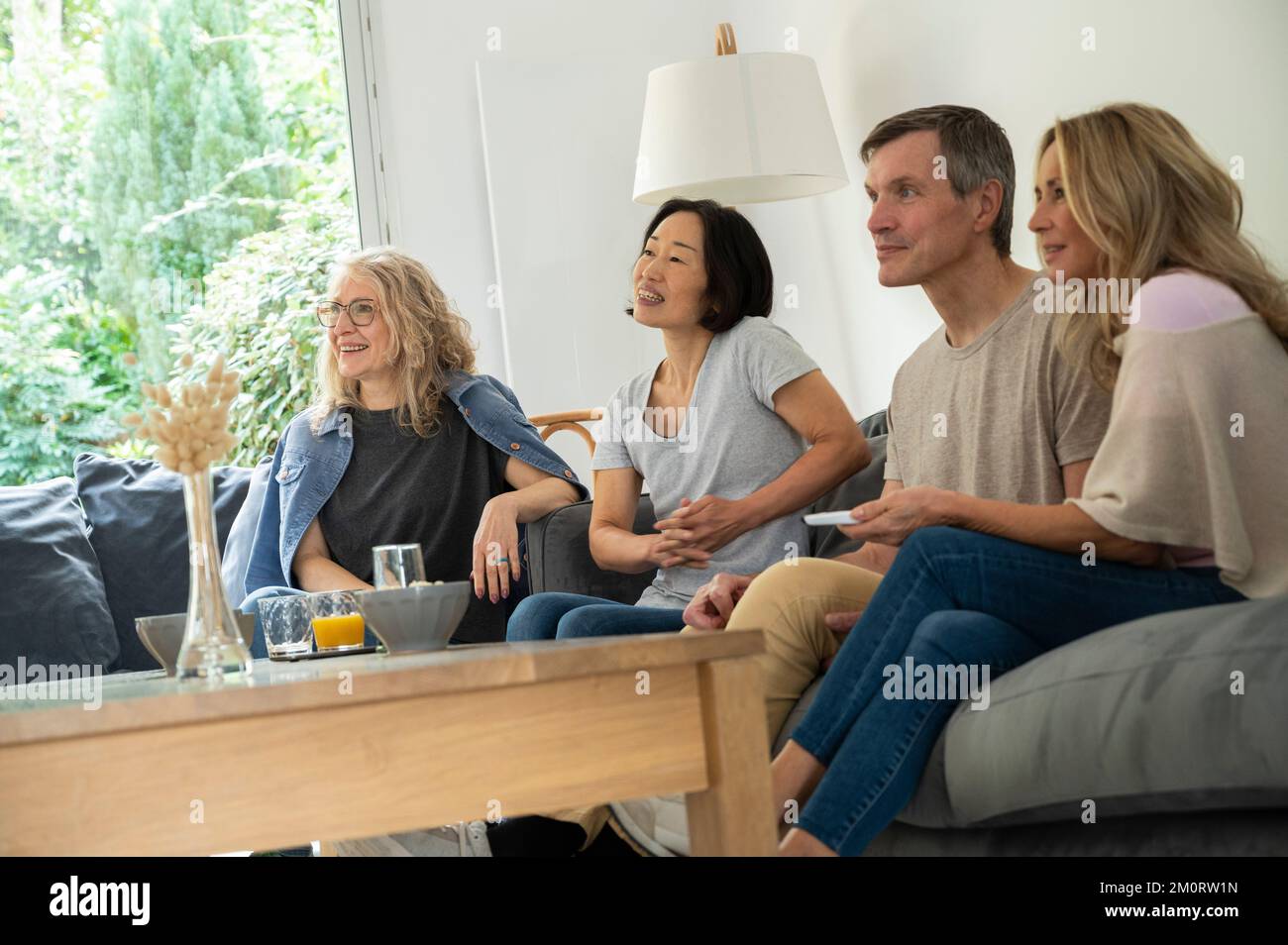 Portrait of diverse group of friends gathered at home to watch a movie ...