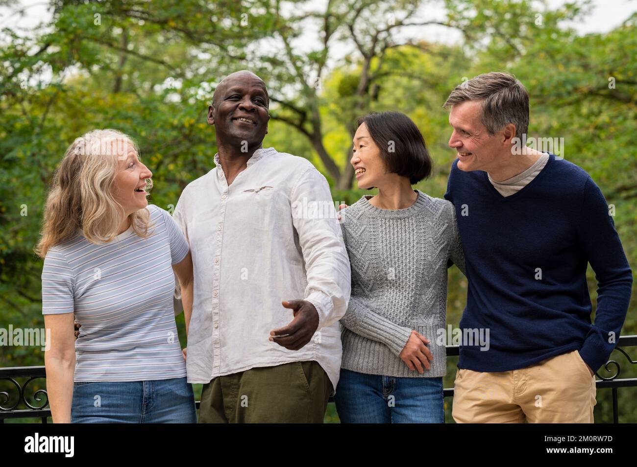 Group of diverse couples enjoying a day out in public park Stock Photo ...