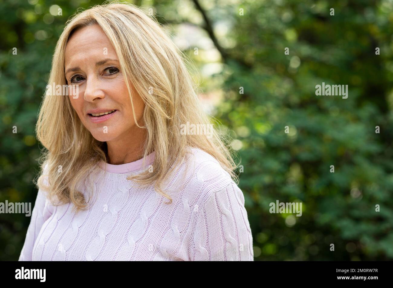 Mid-shot portrait of middle age woman looking at camera while posing ...