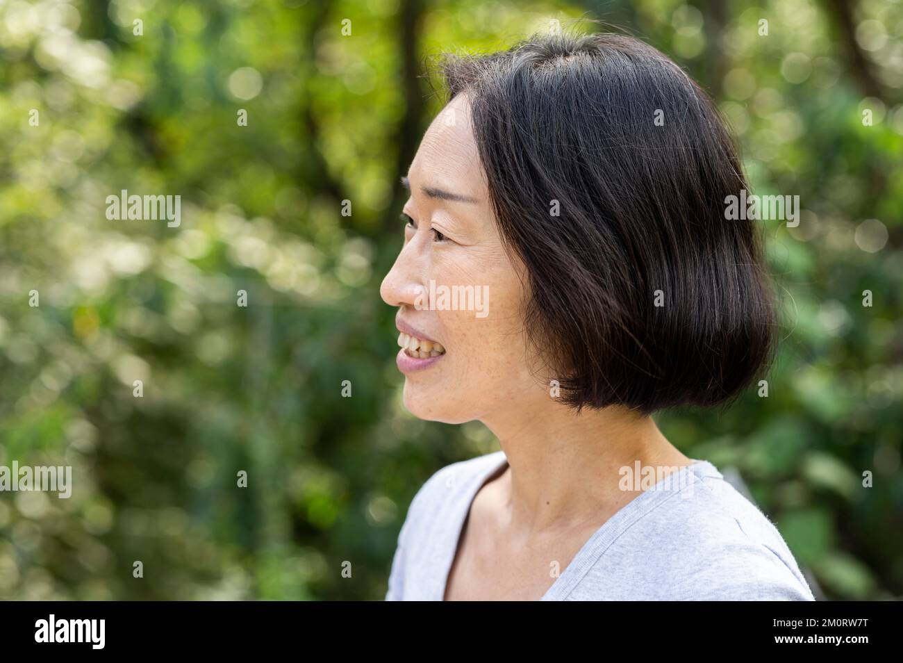 Side view shot of senior Asian-American woman standing outdoors Stock ...