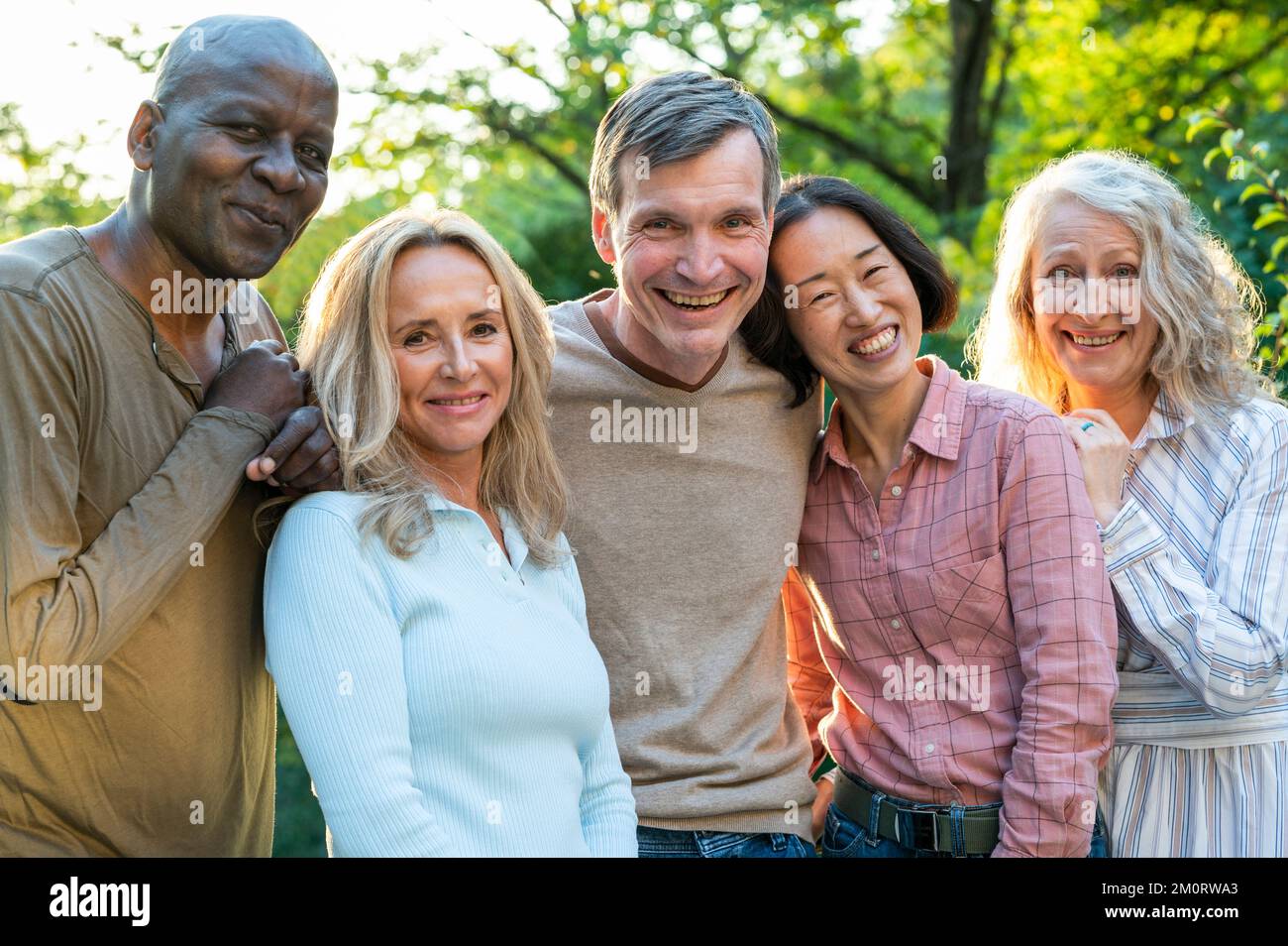 Fun diverse group of middle-aged friends hanging out in backyard at ...