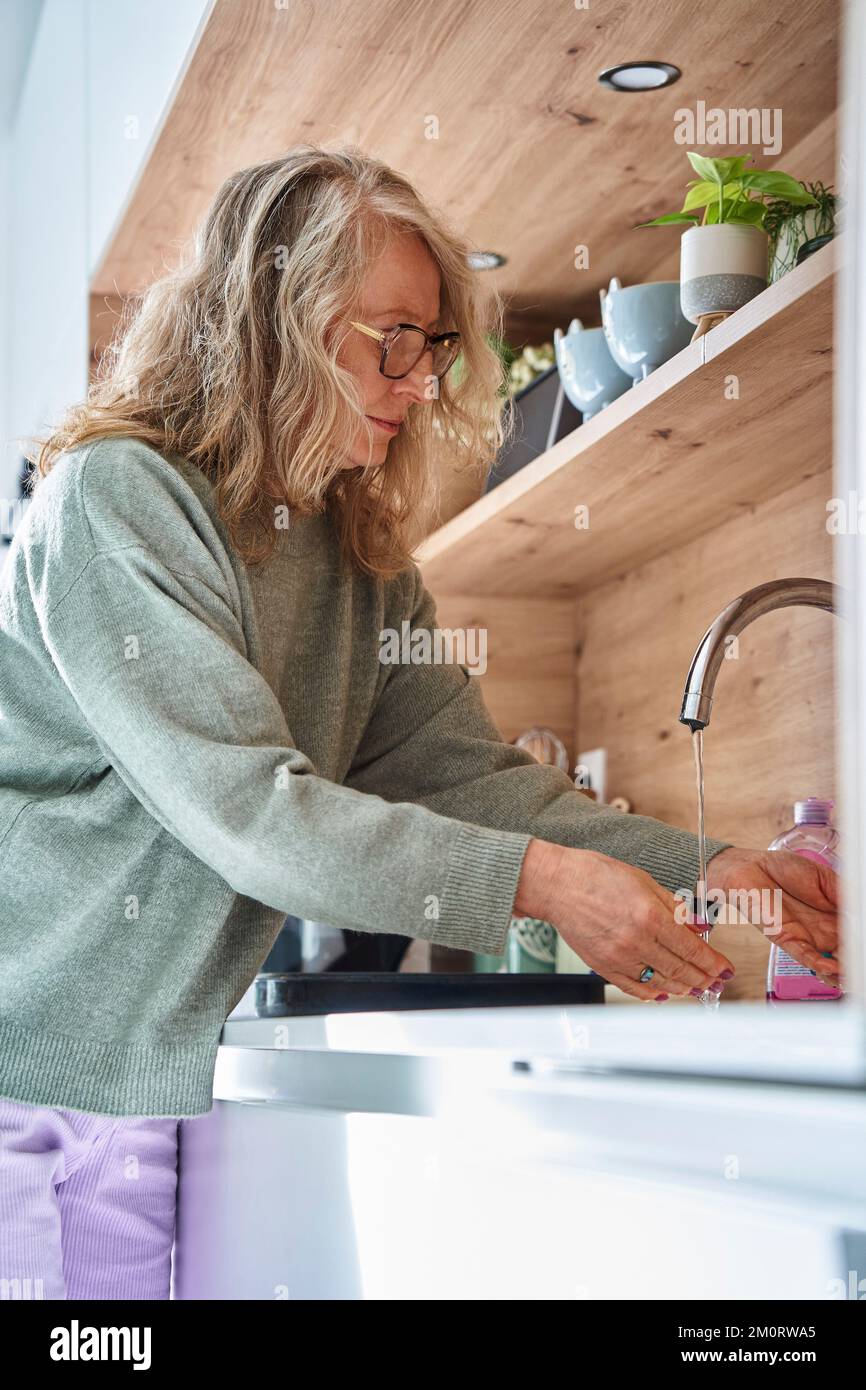 Senior woman doing dishes at kitchen Stock Photo - Alamy