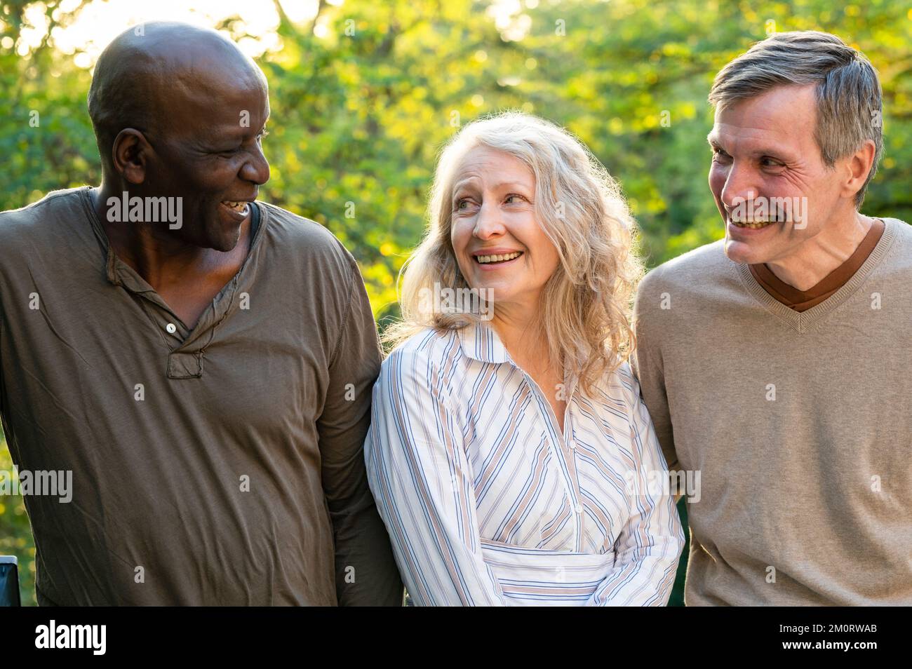 Three middle-aged friends hanging out together ourdoors Stock Photo - Alamy
