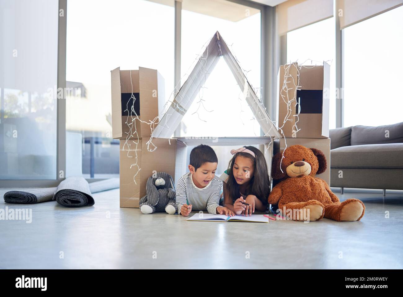 What should we draw. two little siblings drawing together at home Stock Photo - Alamy