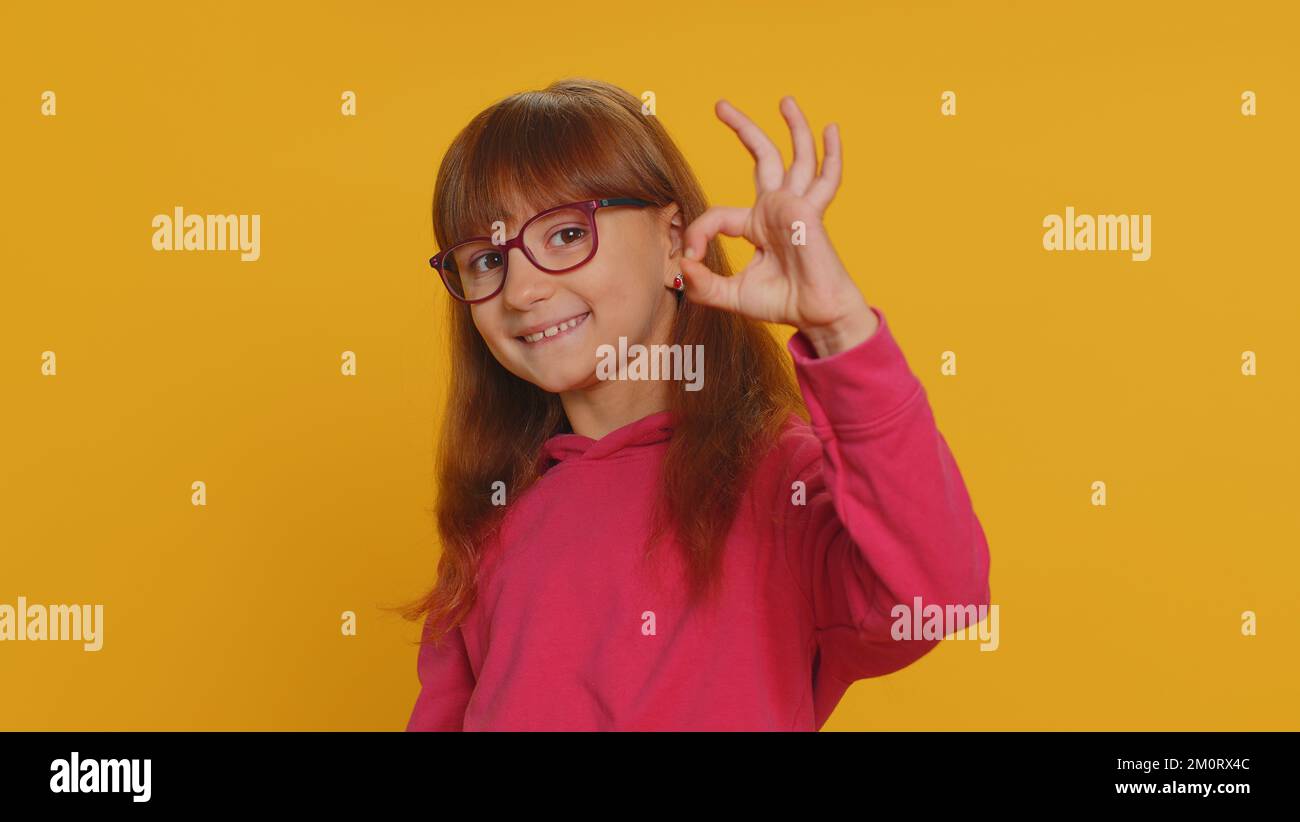 Ok. Young toddler school girl in glasses looking approvingly at camera ...