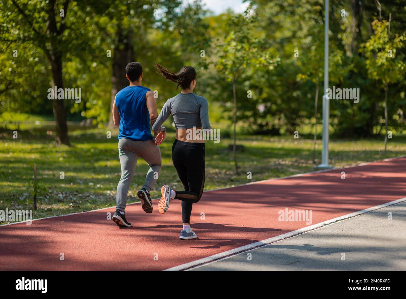A sporty couple running slowly. They are exhausted and slowed their ...