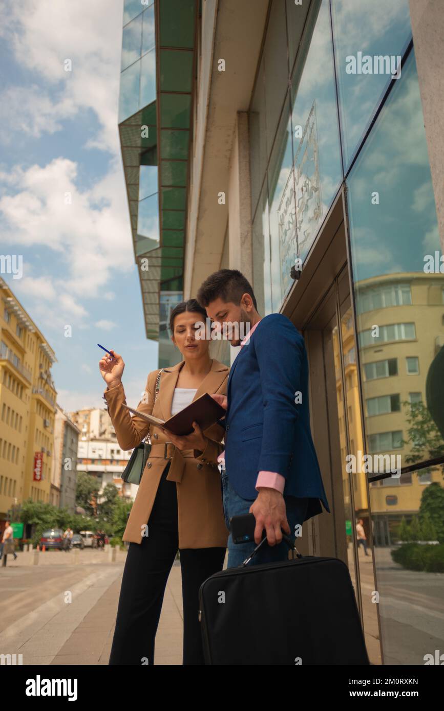 A beautiful business couple are taking a look at their notes they wrote ...