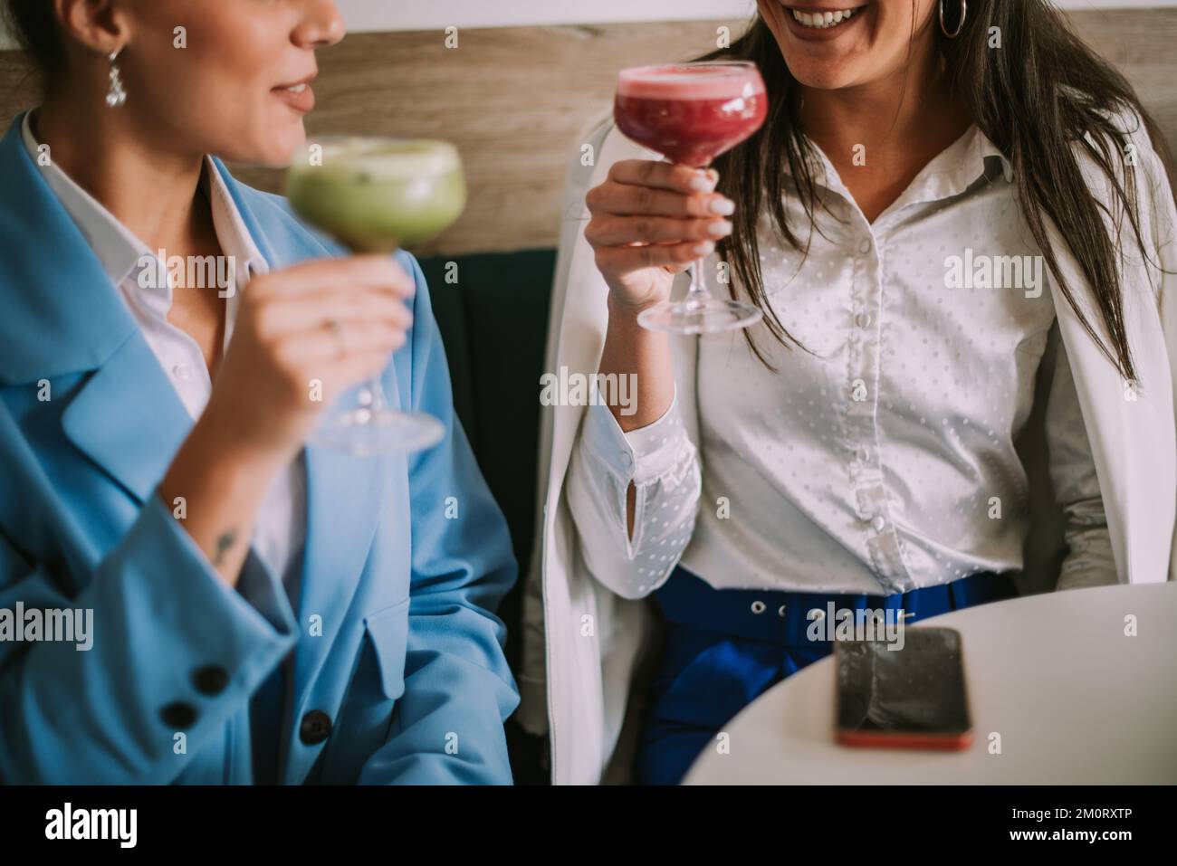 Close up of two business women having a fun time while drinking latte ...
