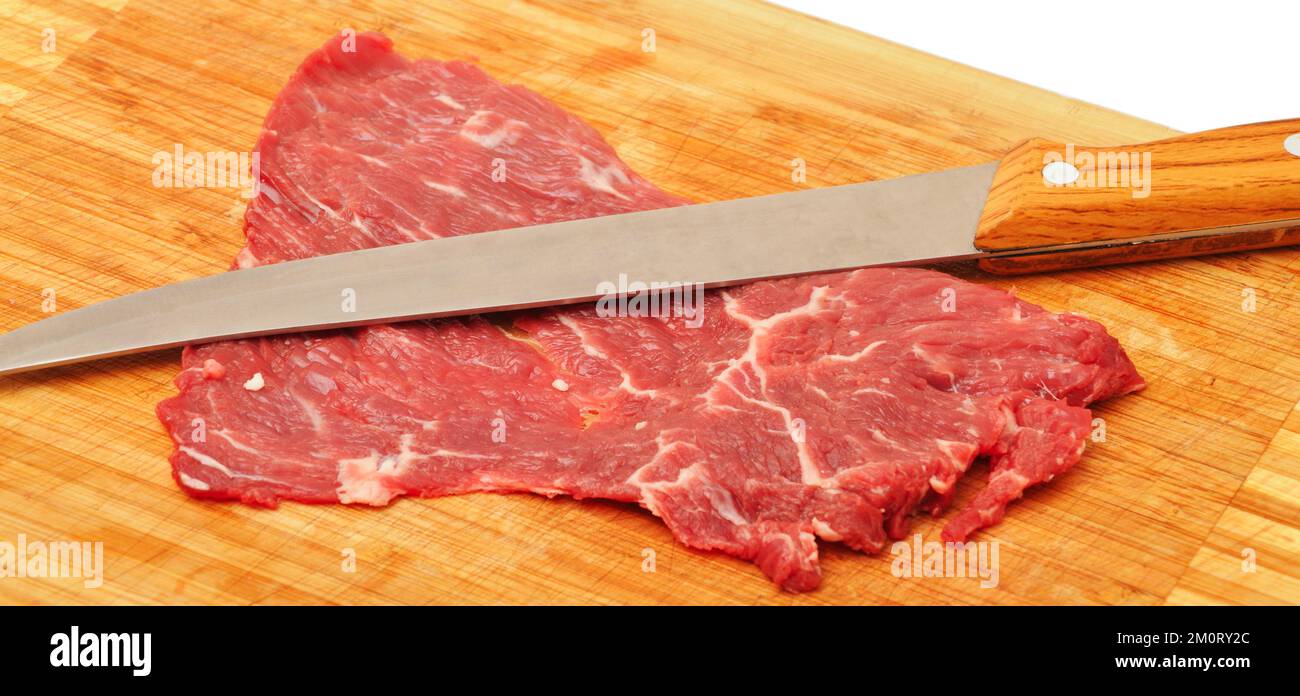 Clean very fresh red raw cow meat and a sharp knife, on cutting board ...