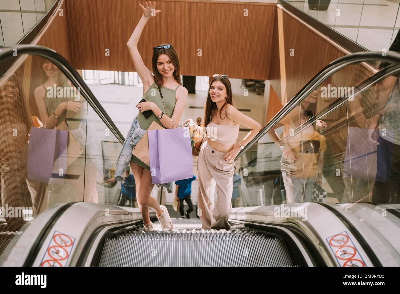 Two amazing girls on the escalator at the mall Stock Photo - Alamy