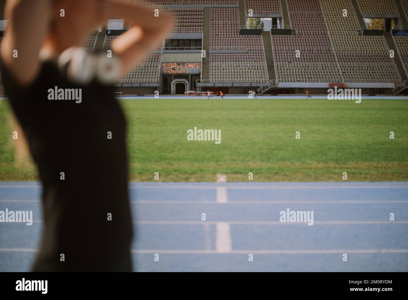 Beautiful female sportsperson is about to run on a stadium's track. She ...