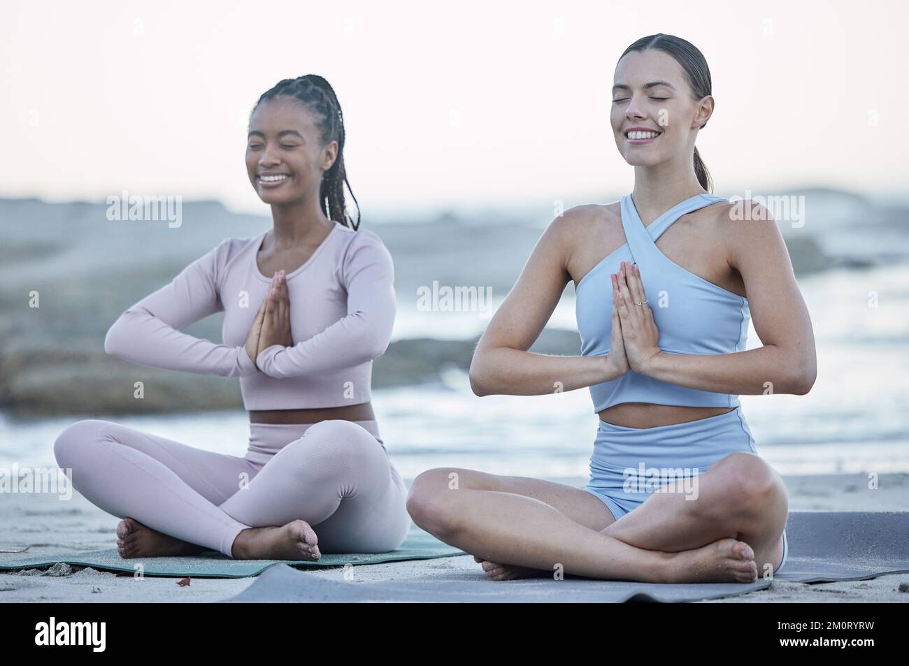Woman, friends and yoga at the beach for meditation, healthy wellbeing ...