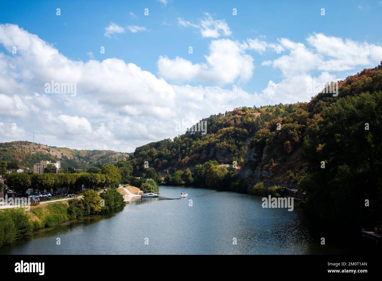 A beautiful landscape of a riverside covered in forests with a cloudy ...