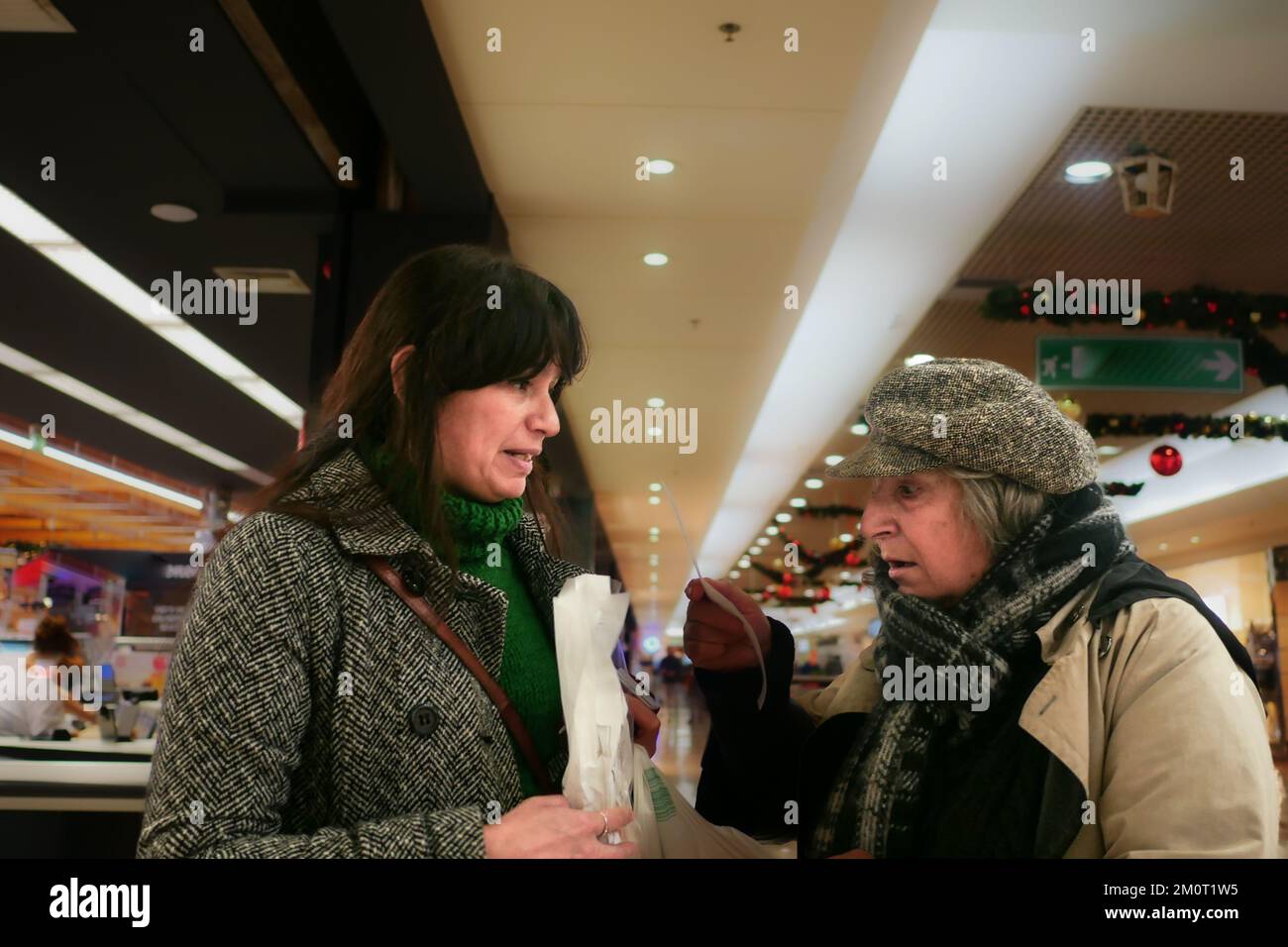 senior european lady and hispanic young adult woman controlling the ...