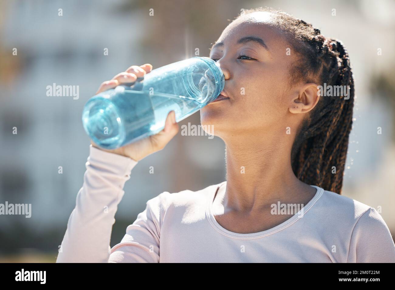 Drinking water, fitness and black woman in urban city with workout ...