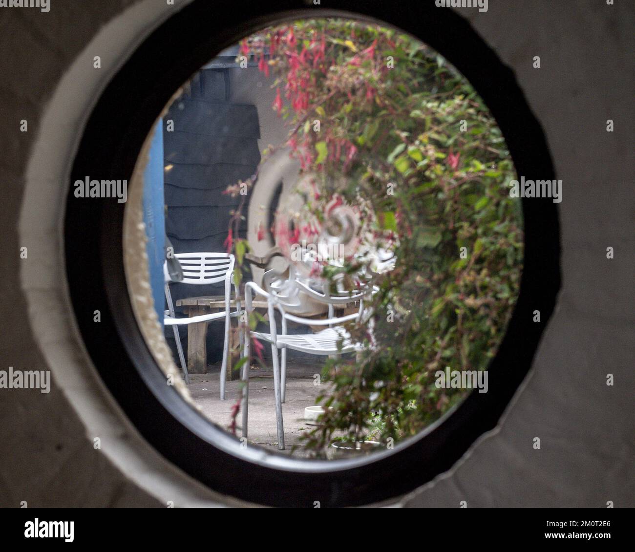 The view of a patio garden with chairs from a porthole window Stock ...