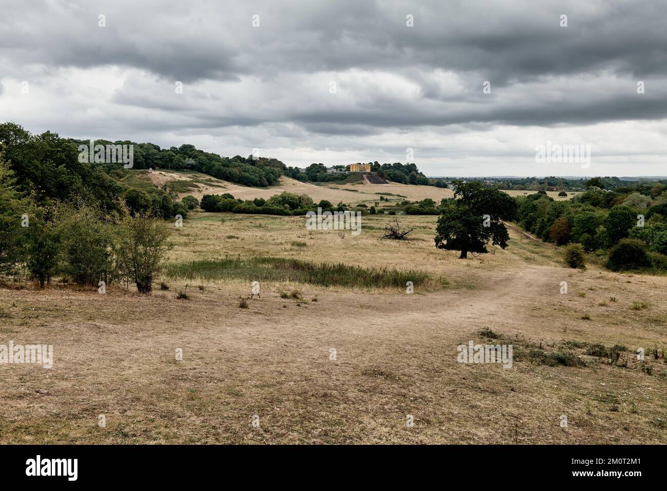 The dark clouds over the dry field with a path Stock Photo - Alamy