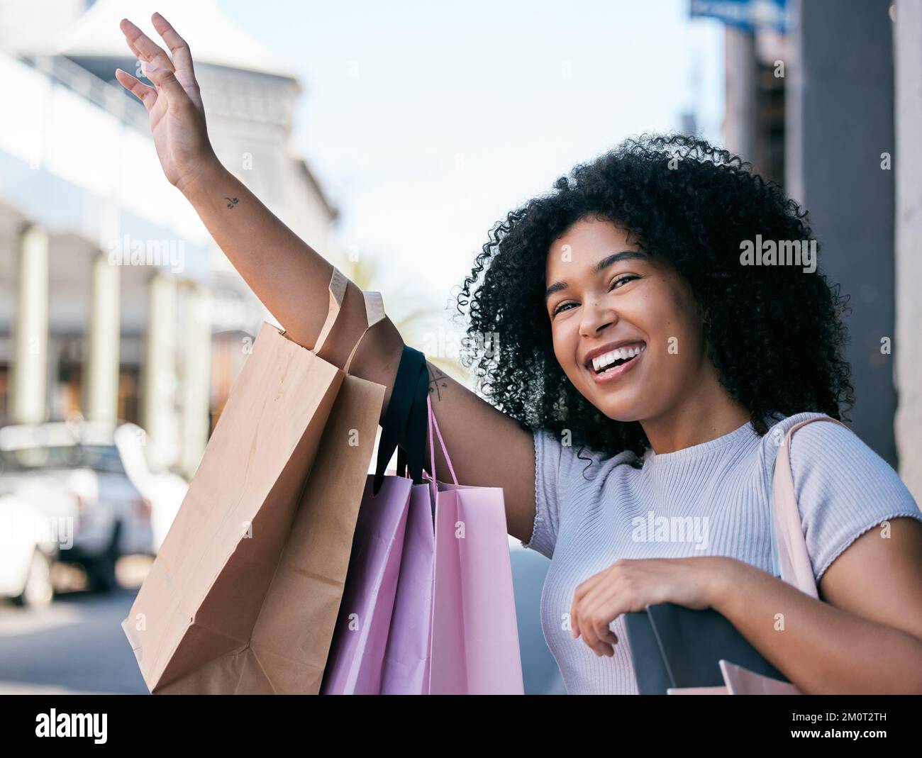 Black woman while shopping with smile and shopping bag, wave in outdoor ...