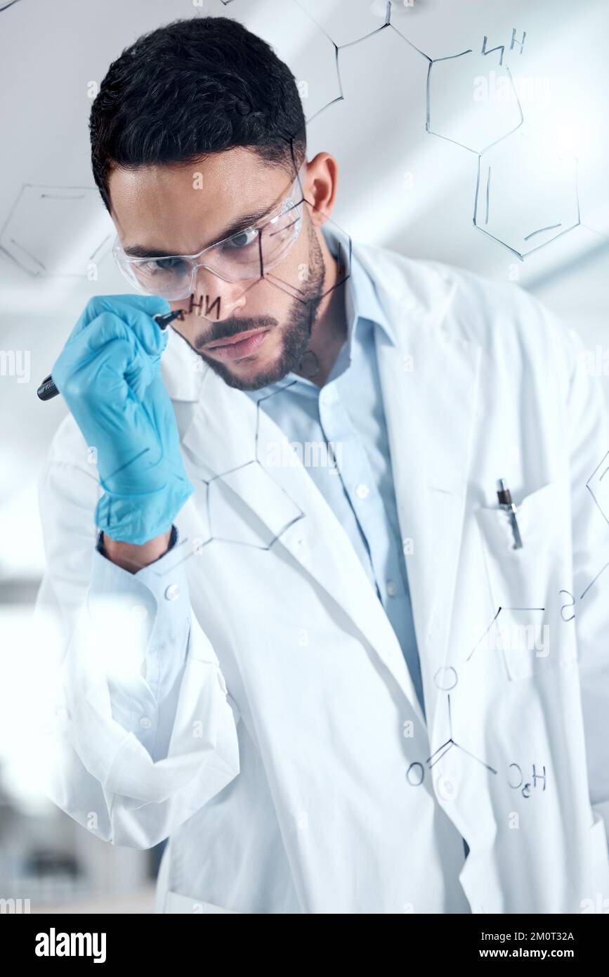 One serious young mixed race male scientist writing and planning on a ...