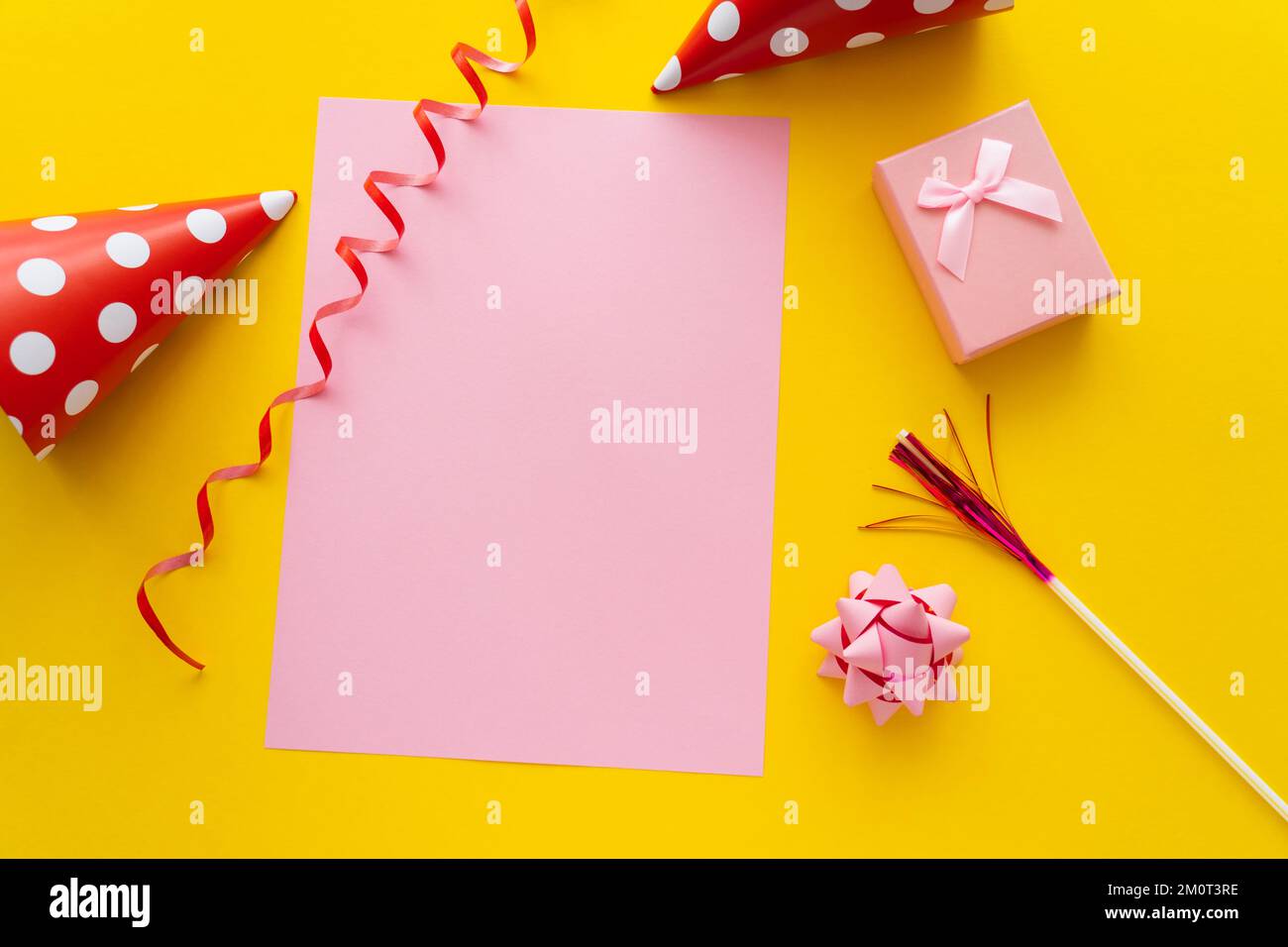 Top view of empty greeting card near dotted party caps and gift box on ...