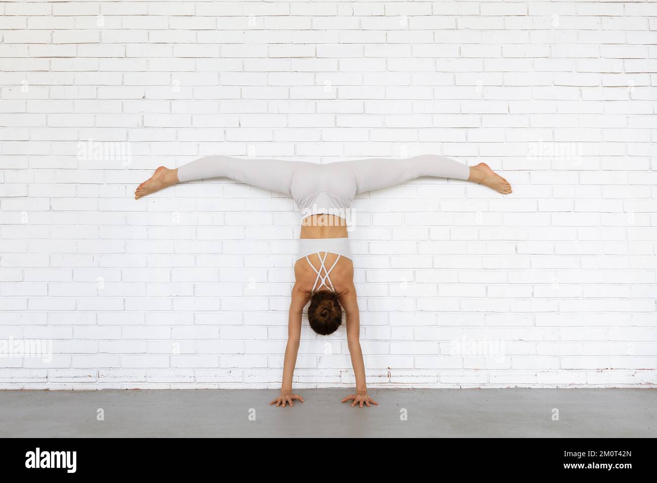 Young Woman Trainer Practicing Yoga Doing Adho Mukha Vrikshasana