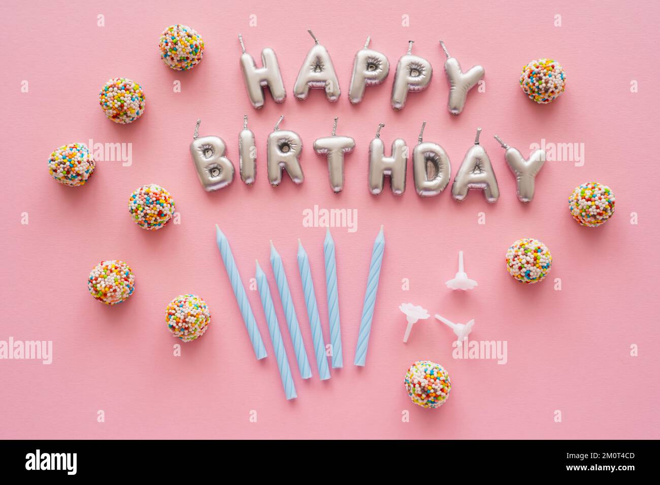 Top view of candles in shape of Happy Birthday lettering near candies ...