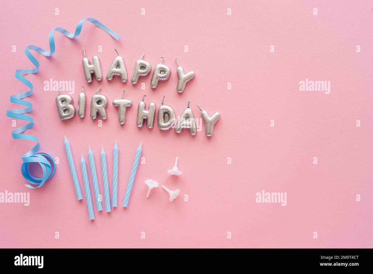 Top view of candles in shape of Happy Birthday lettering near blue ...