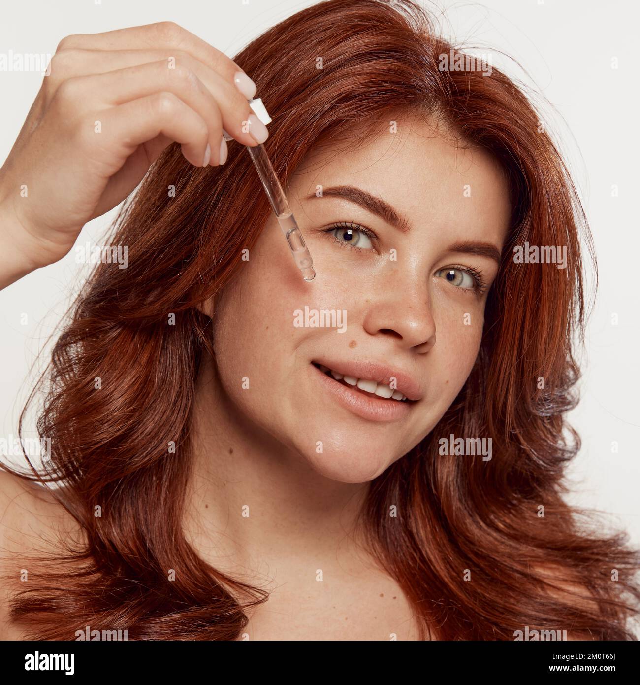 Portrait of young, beautiful, red-haired woman taking care after skin ...