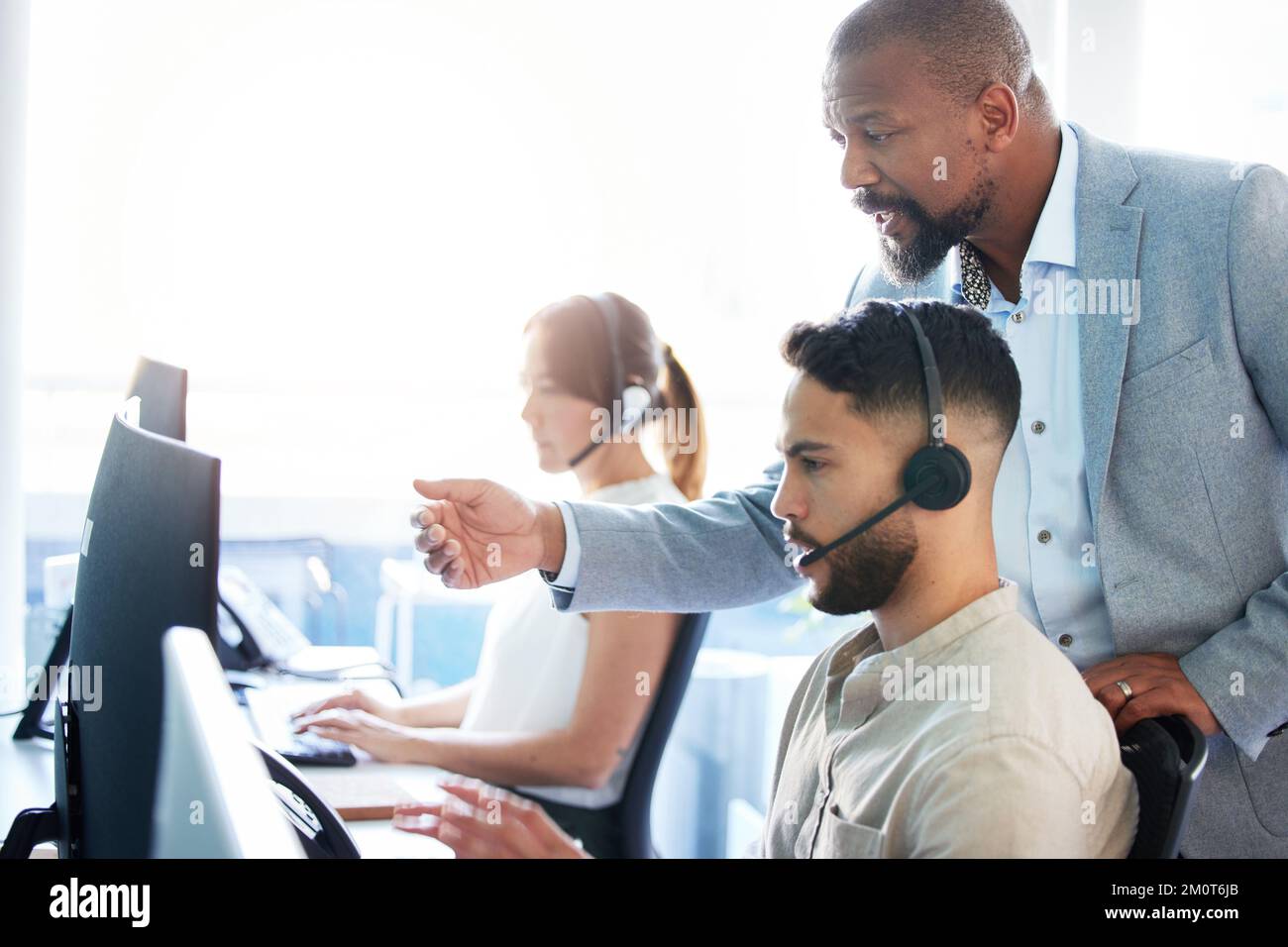 Access the clients account. a mature businessman standing and helping ...