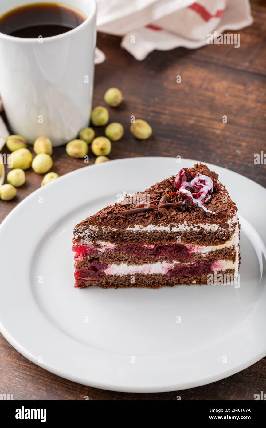 Cherry cake on white porcelain plate on wooden table Stock Photo - Alamy