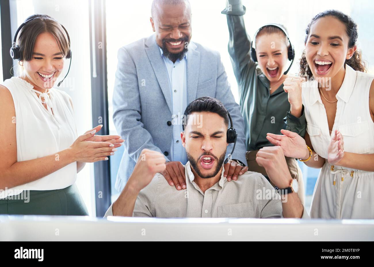 Watching him do his best. a handsome young call centre agent sitting ...