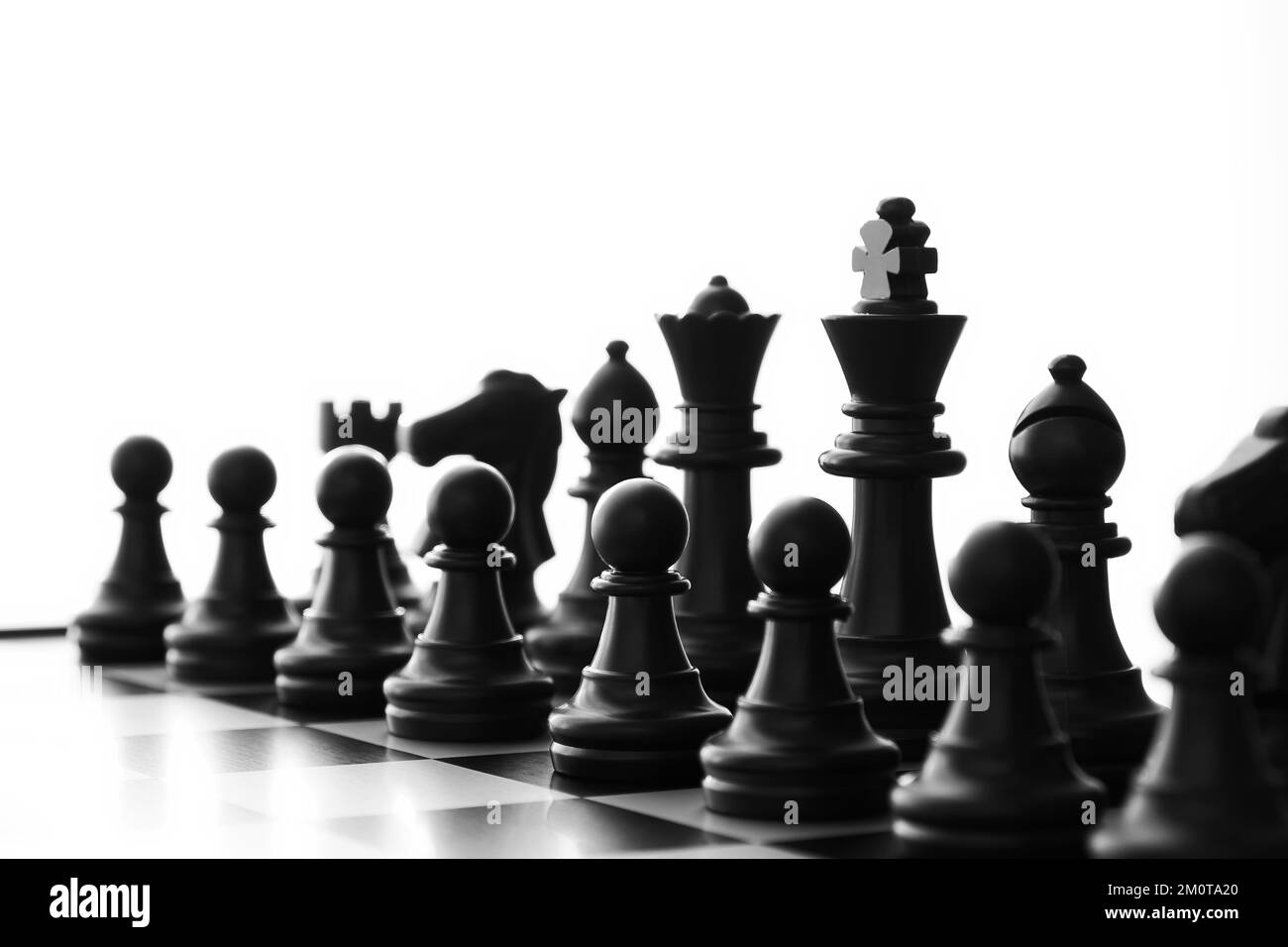 Isolated black Chess army ready for battle on a board with blurred ...